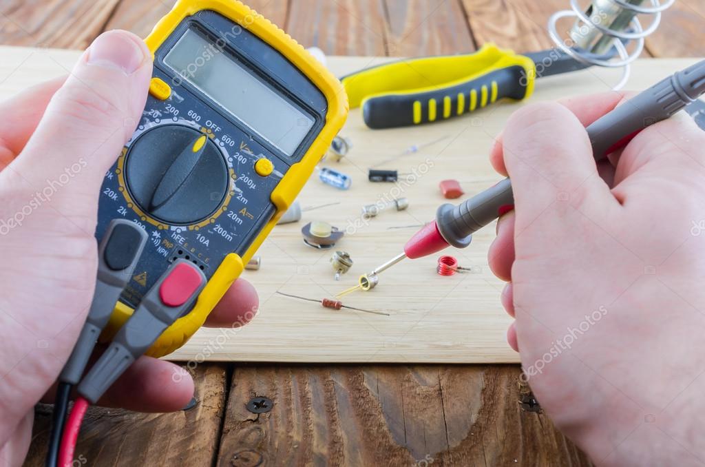 The workplace of serviceman. Hands holding the multimeter. Stock Photo ...