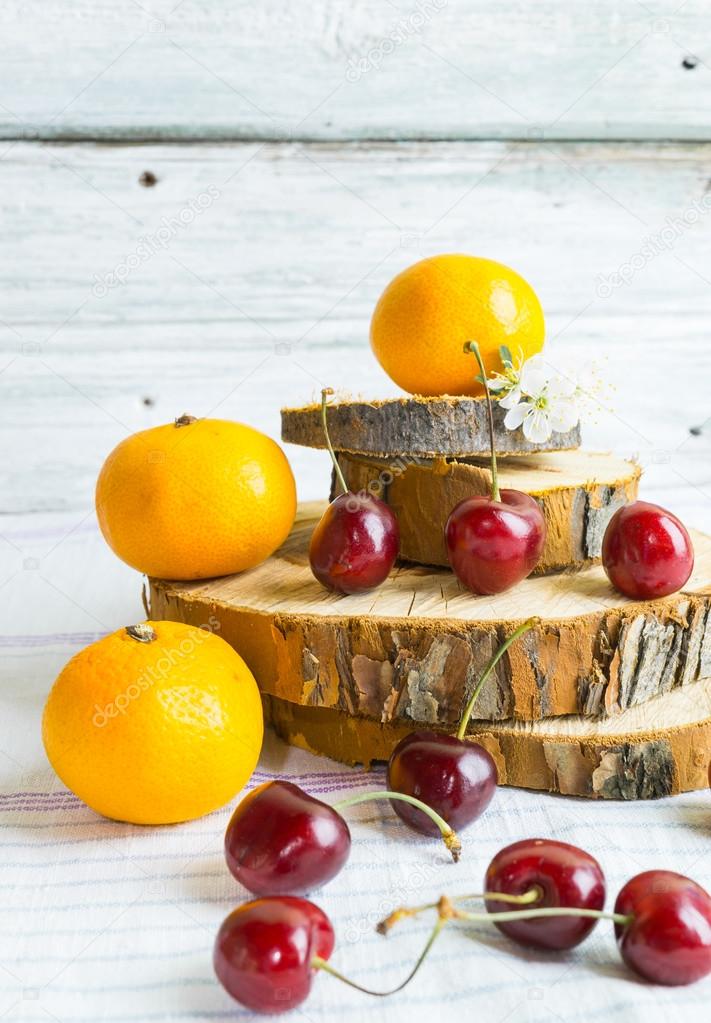 Red cherries and oranges on wooden plate — Stock Photo © Angelus_Liam ...