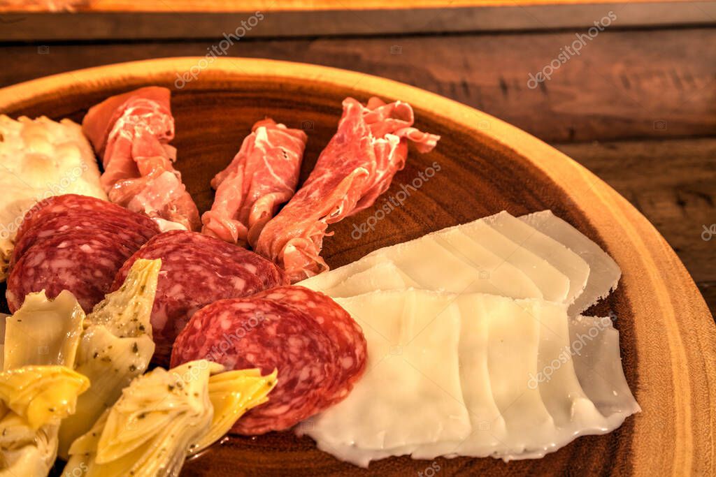 Tabla de charcutería sobre madera rústica con velas detrás de una ...