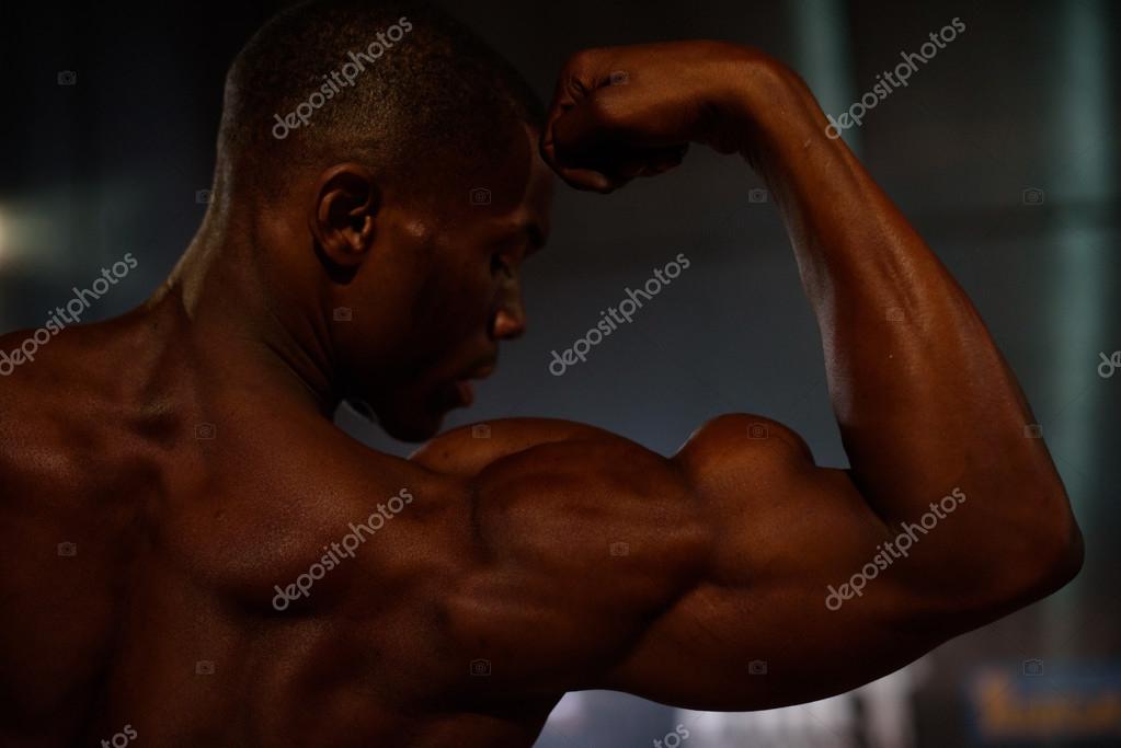 Side view of black african american fitness model showing muscles close ...