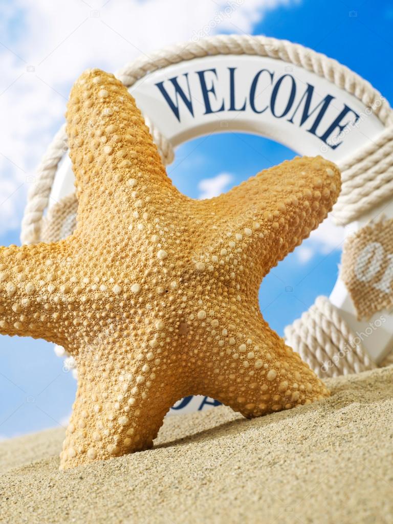 Starfish and welcome sign on beach Stock Photo by ©Goir 102547256