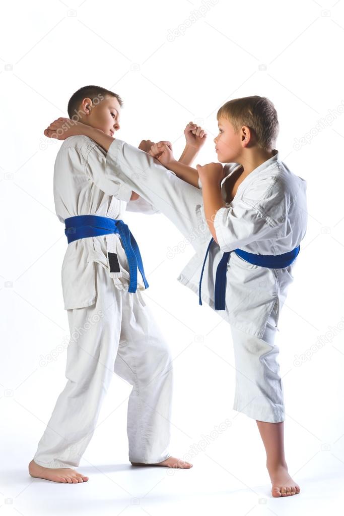 Karate boy en kimono luchando sobre un fondo blanco — Foto de stock ...