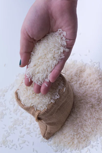Hand scoop rice grain in sack. - Stock Image - Everypixel