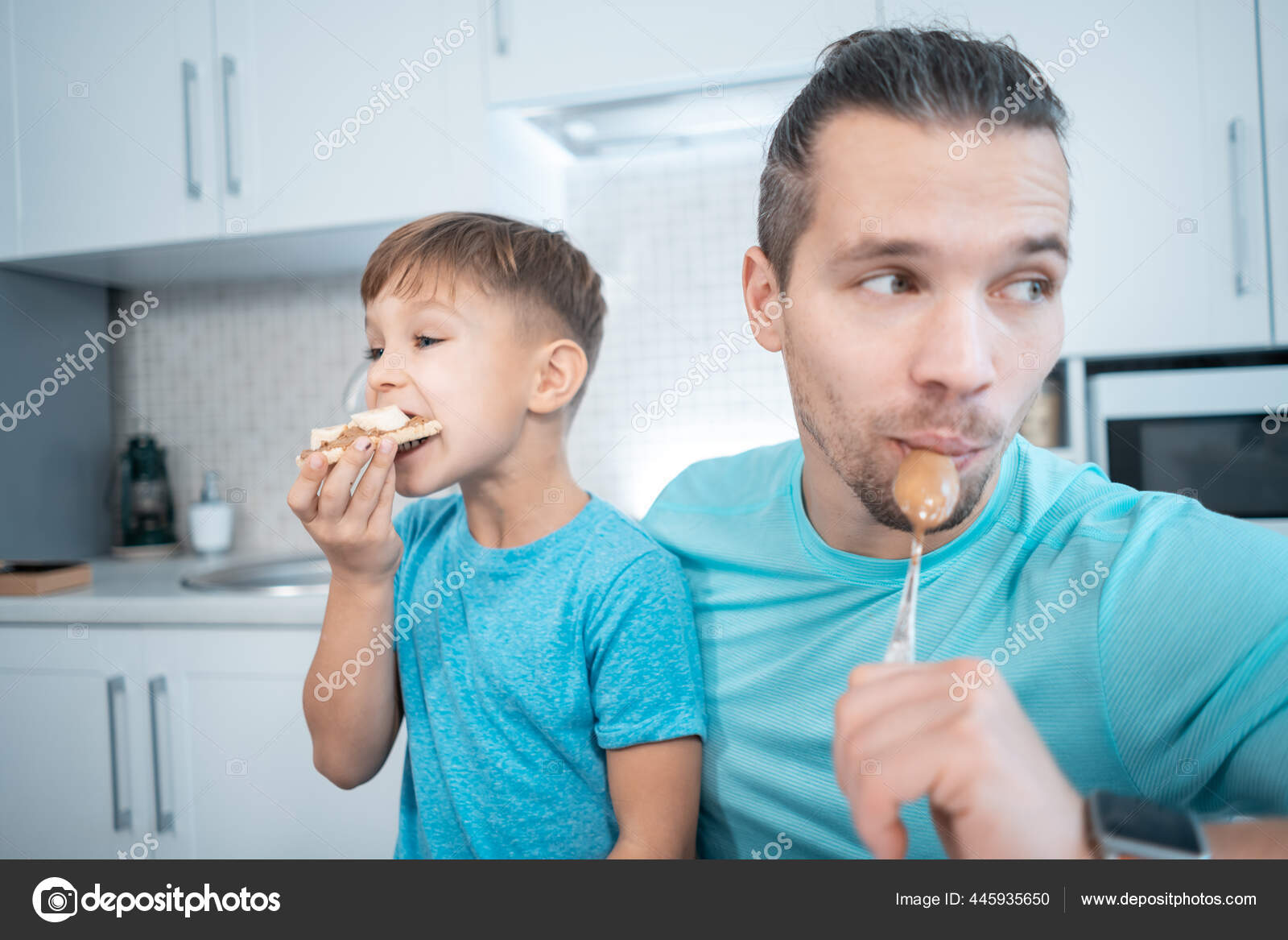 Happy kid boy and father eating healthy peanut butter toast at home ...