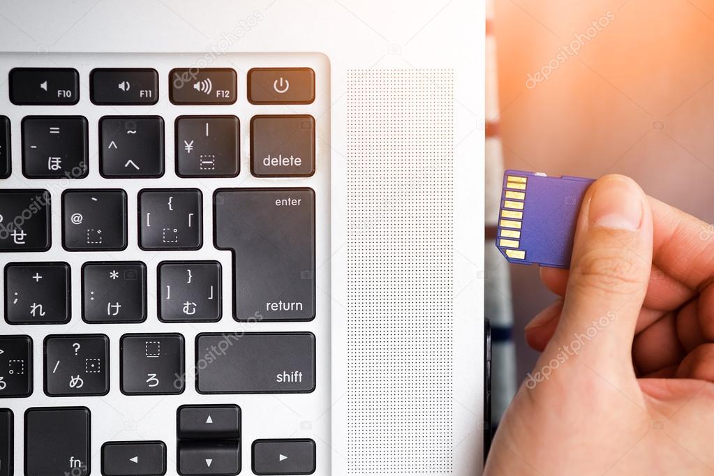 Plugging in SD Card into personal computer ready for photo file ...