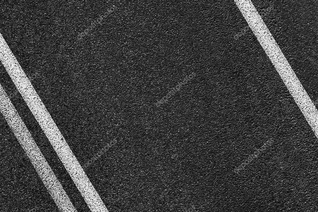 Camino asfaltado nivel con una división de rayas blancas. La textura de ...