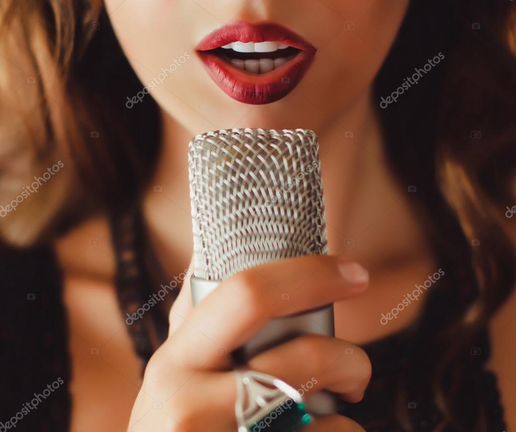 Beautiful girl singing into microphone — Stock Photo © sergey_causelove ...