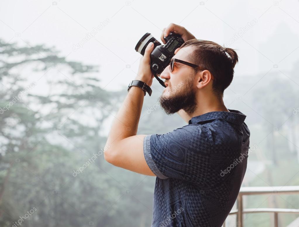Happy young guy with big camera Stock Photo by ©sergey_causelove 96938648
