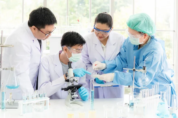Team work asian woman and man Scientists analyzing study data and ...