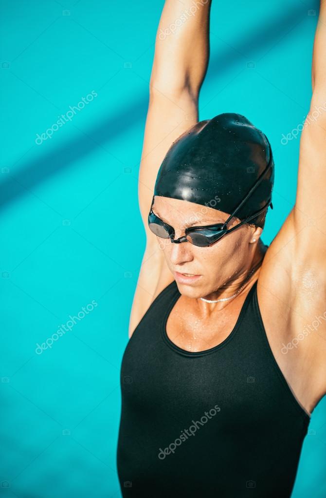 Female warming up before swimming. Stock Photo by ©microgen 115179488