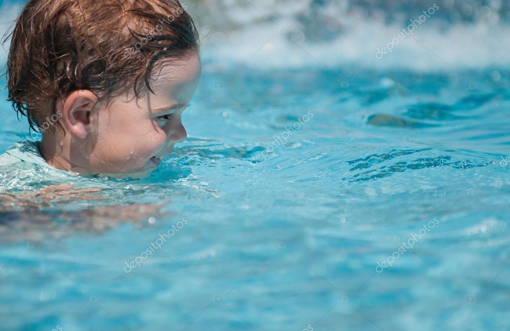 Cute boy in swimming pool Stock Photo by ©microgen 115179972