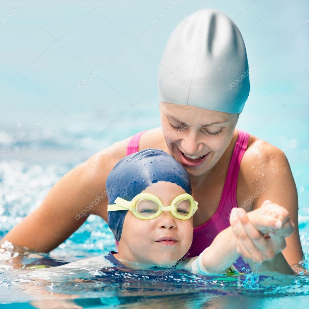 Swimming instructor teaching child to swim Stock Photo by ©microgen ...