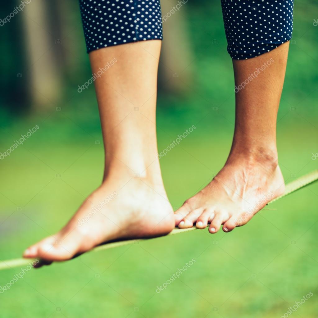 Female legs balancing barefoot on Slackline — Stock Photo © microgen ...
