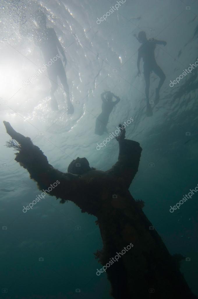 Snorkelers swimming over Christ statue — Stock Photo © microgen #115988848