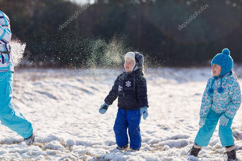 Two kids throwing snowballs at mother — Stock Photo © mavoimages #98527202
