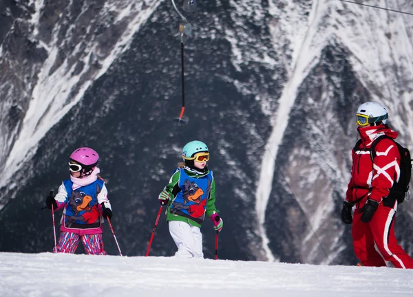 Ski instructor and two young skiers on the hill. Ski resort in Austria ...
