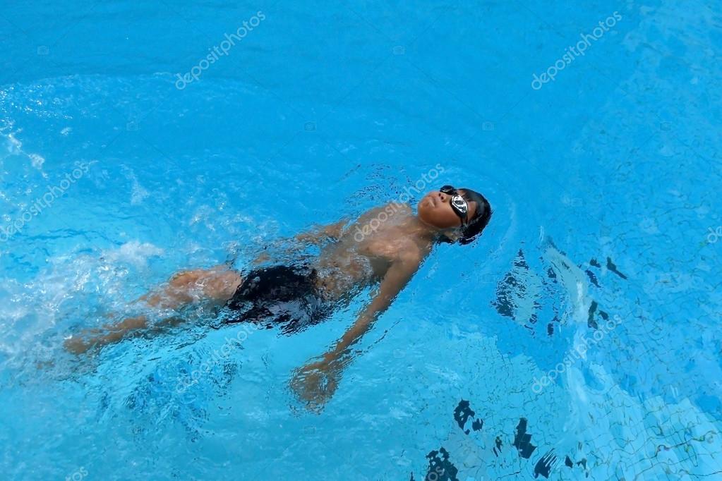 Happy boy swim in the swimming pool - back stroke kick — Stock Photo ...