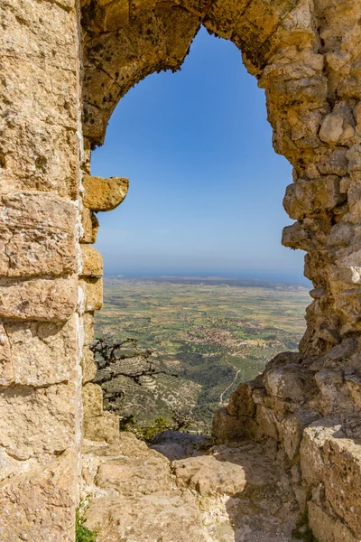 View through arched castle window to sunset coastal landscape, cornwall ...