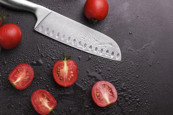 Cutted tomatoes and stainless steel vegetables knife.Dark stone - Stock ...