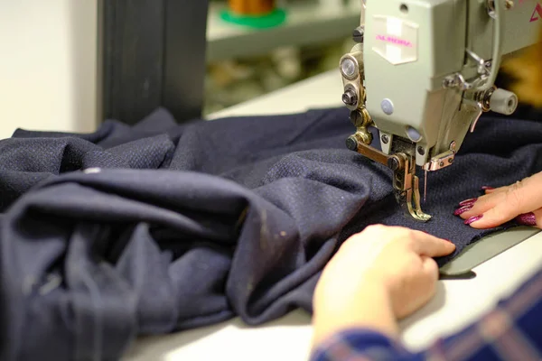 Female hands stitching white fabric on professional manufacturing ...