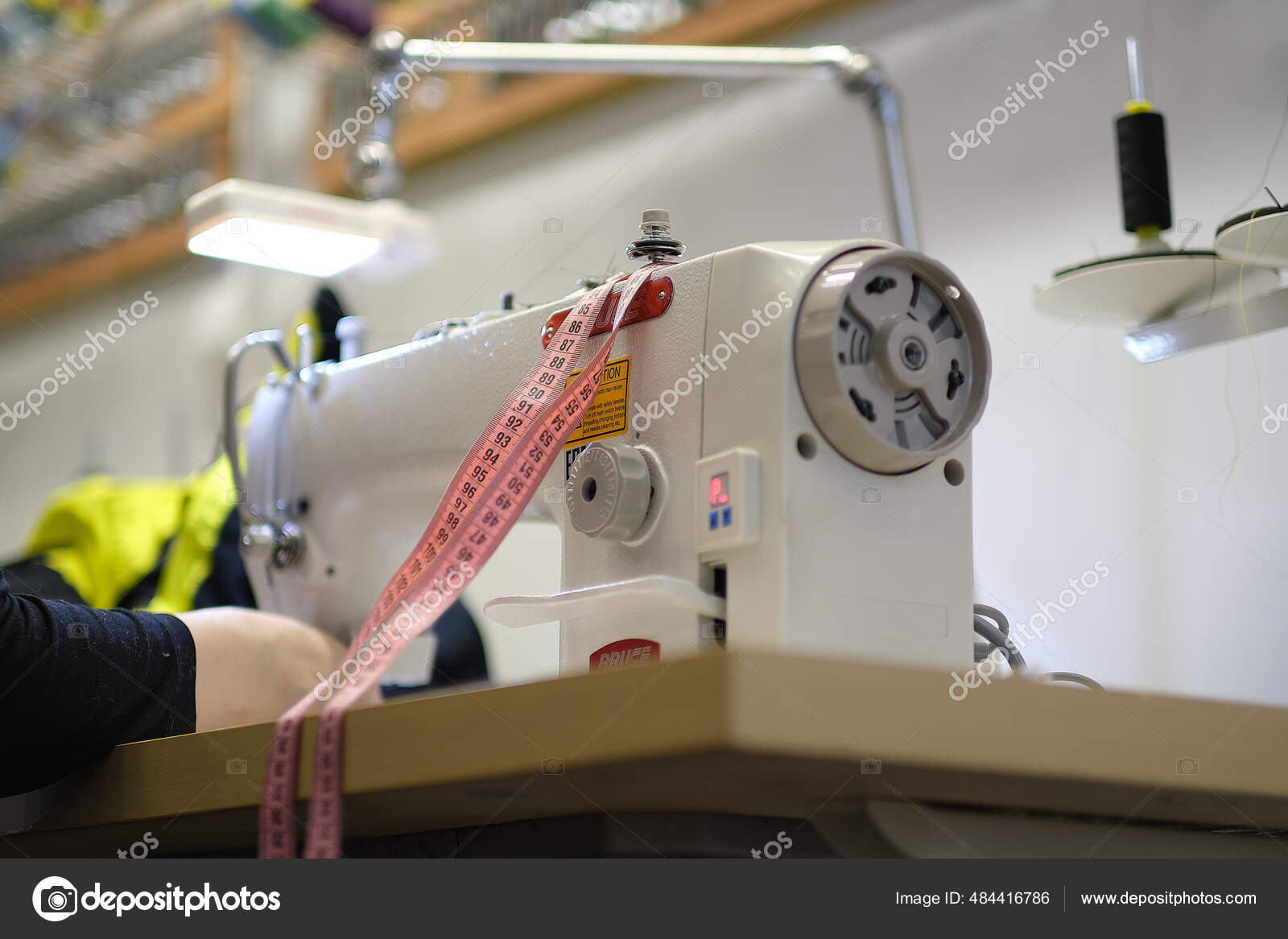 Female hands stitching white fabric on professional manufacturing ...