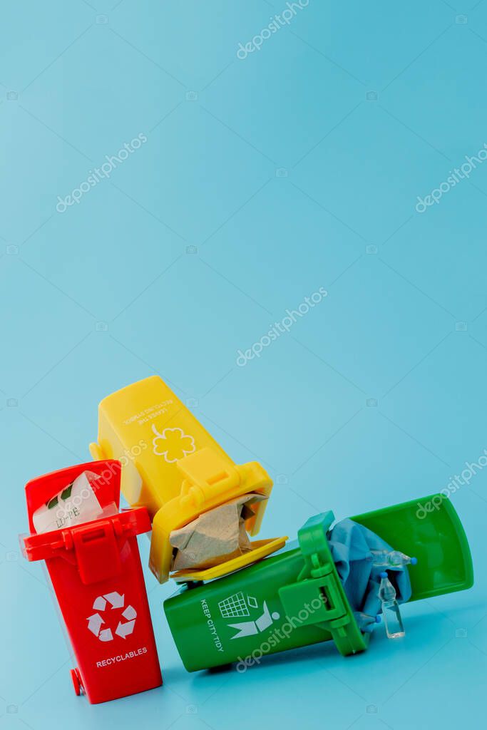 Papeleras de reciclaje amarillas, verdes y rojas con símbolo de reciclaje sobre fondo azul ...
