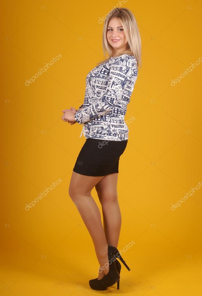 Beautiful young girl posing on a yellow background — Stock Photo ...