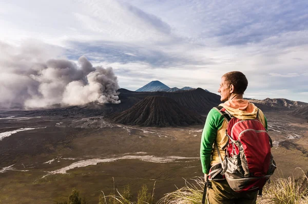 Man on the hill is looking on Bromo volcano eruption. East Java ...