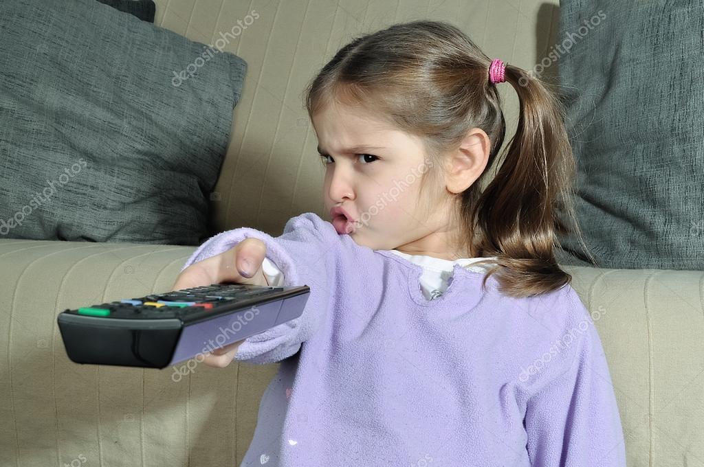 Little girl watching tv. Little girl tantrum with her remote in hand ...
