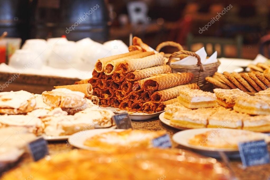 Different types of sweet pastries on plates at counter cafe — Stock ...