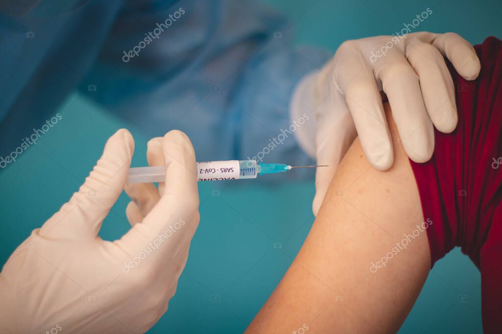 científico con un traje protector inyectando una jeringa con una ...