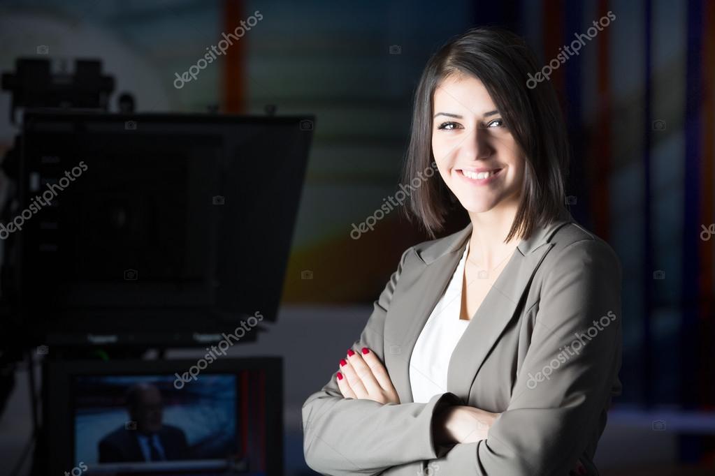 Young beautiful brunette television announcer at studio standing next ...