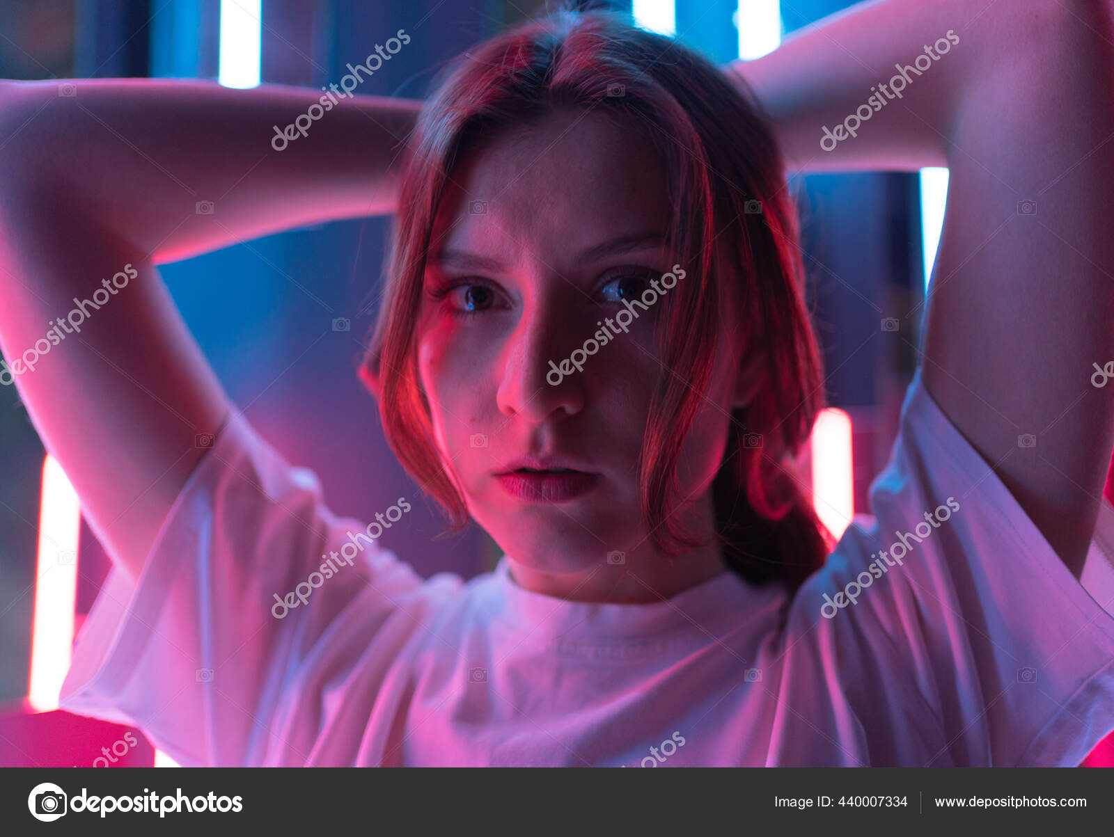 Fashion and neon - a model poses in the light of glowing neon lamps ...