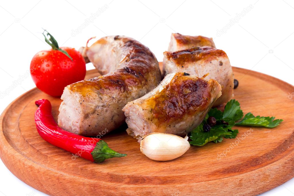 embutidos de cerdo frito en un plato de madera con tomates cherry y ...