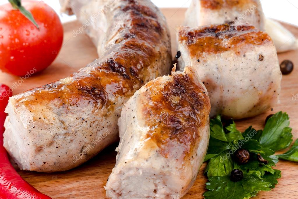 embutidos de cerdo frito en un plato de madera con tomates cherry y ...