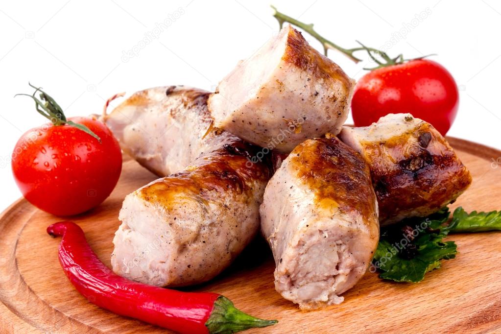 embutidos de cerdo frito en un plato de madera con tomates cherry y ...