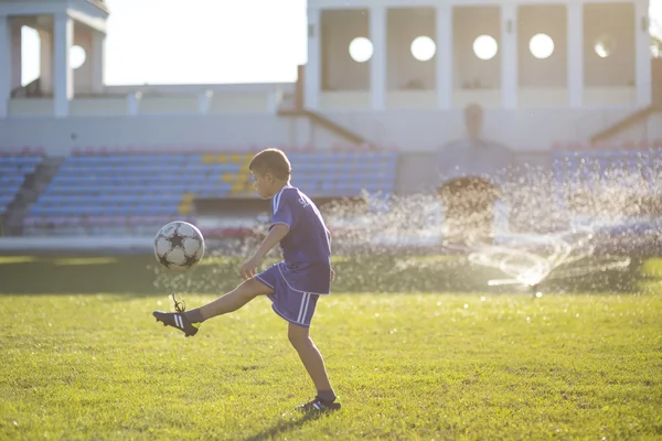 Boy kicking soccer on the footboll field — Stock Photo © oleksandrserbinov.gmail.com #124060510