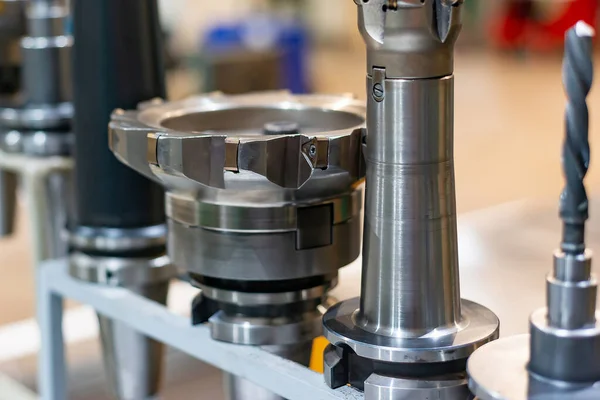 Arbors with cutters and drills for a CNC machine on a rack, tools and ...