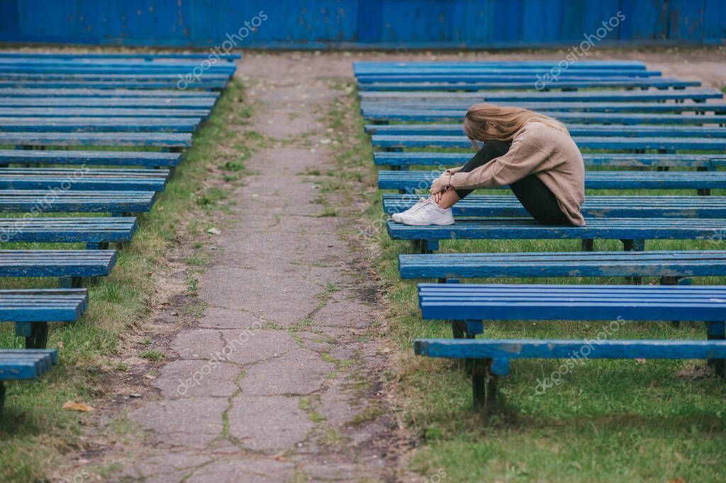 Retrato de una chica solitaria y triste sentada en un banco en un lugar ... Retrato de una chica solitaria y triste sentada en un banco en un lugar ...
