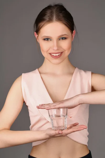 Lady holding glass in her hands. Close up. Gray background - Stock ...