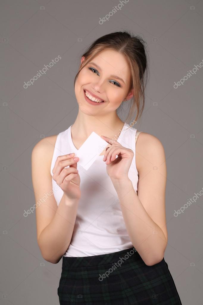 Smiling model posing with note. Close up. Gray background Stock Photo ...
