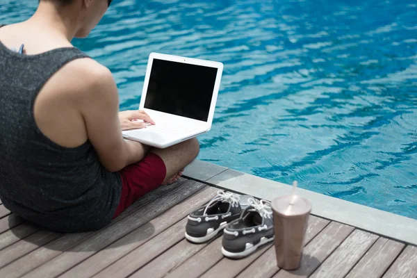 Businessman working with laptop computer at swimming pool. - Stock ...