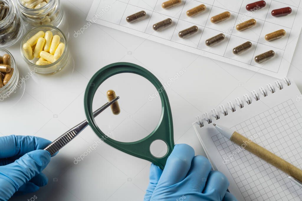 La mano de un médico o farmacéutico con guantes azules sostiene una ...