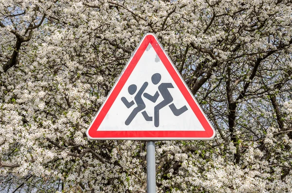 A road sign indicating the approach of a vehicle to a pedestrian ...
