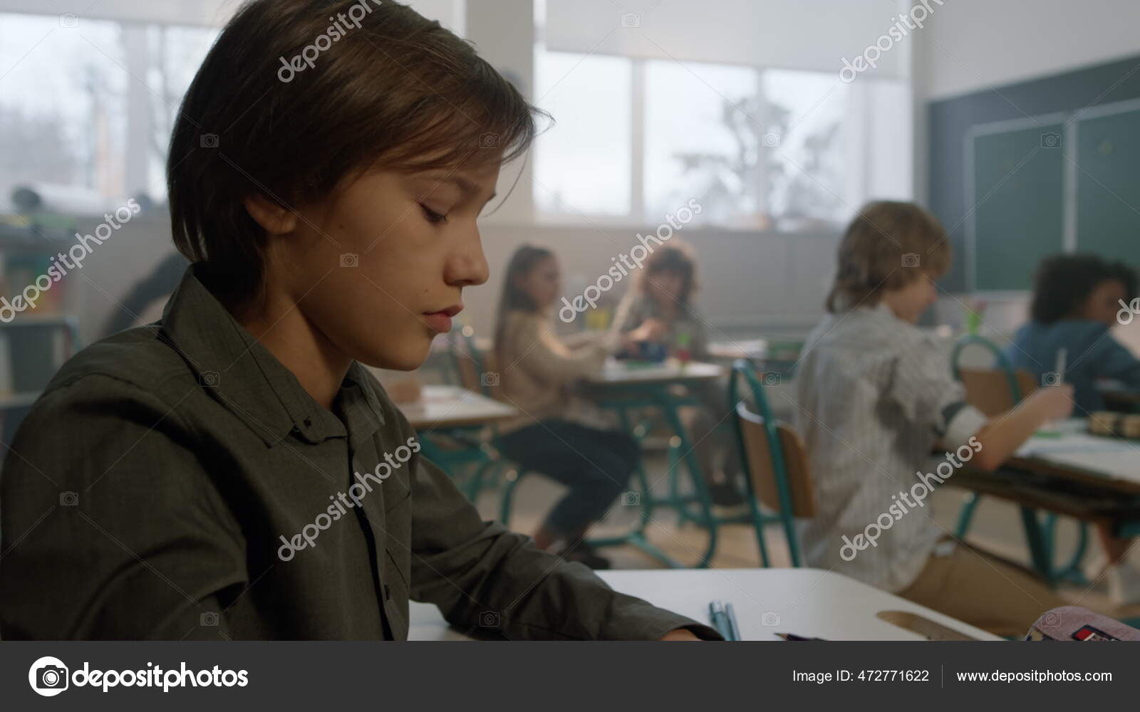 Boy learning in classroom. Smart student looking at blackboard during ...