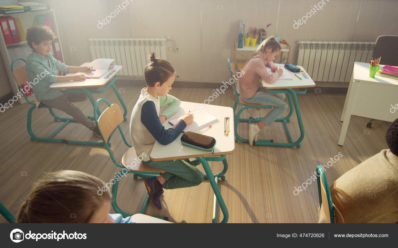 Students doing class work. Schoolboys and schoolgirls writing in ...
