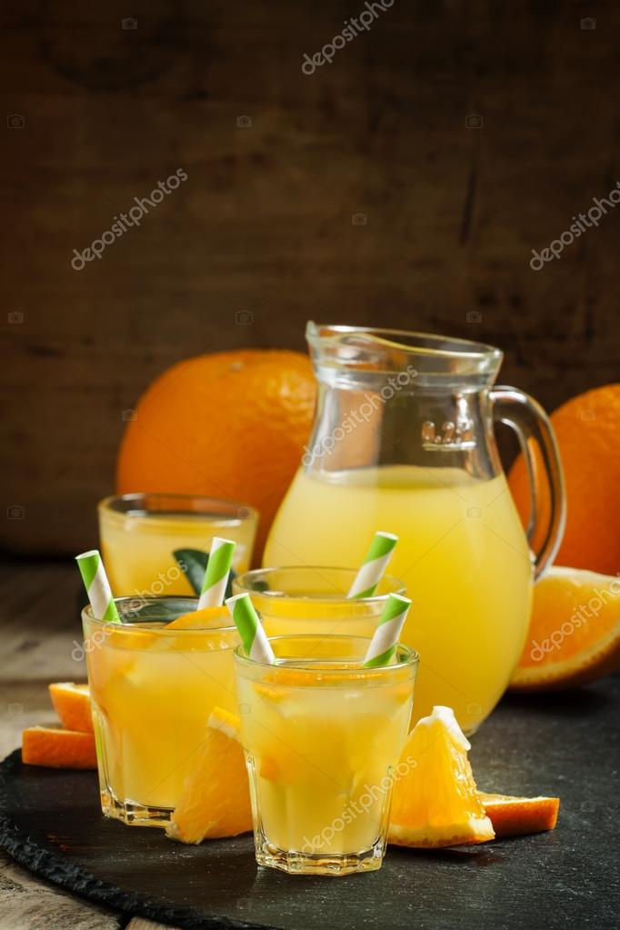 Orange drink in small glasses with striped straws and pitcher Stock ...