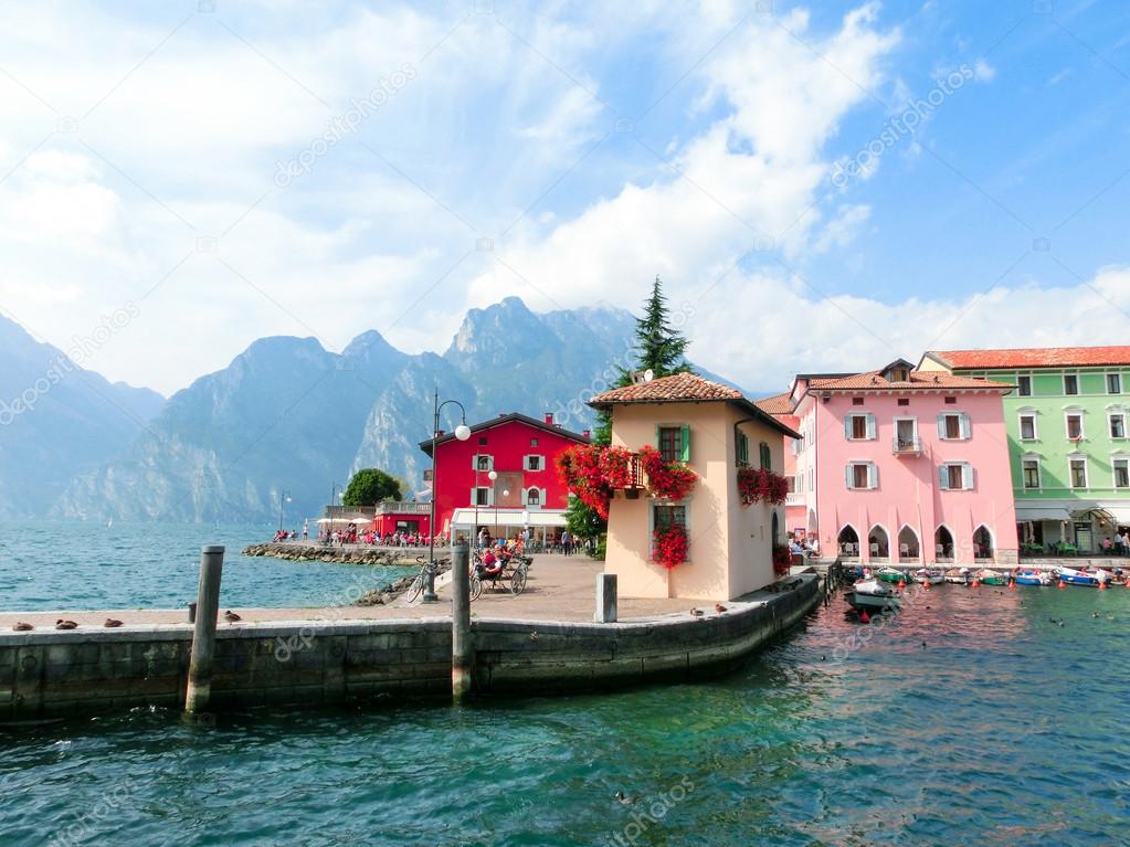 Torbole, Italy - Lake Garda boardwalk with houses, tourists and boats ...