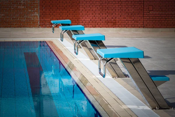 Swimming pool starting blocks in a row - Stock Image - Everypixel