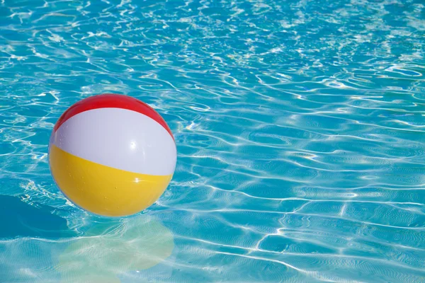 A colorful beach ball floating in a swimming pool Stock Photo by ...